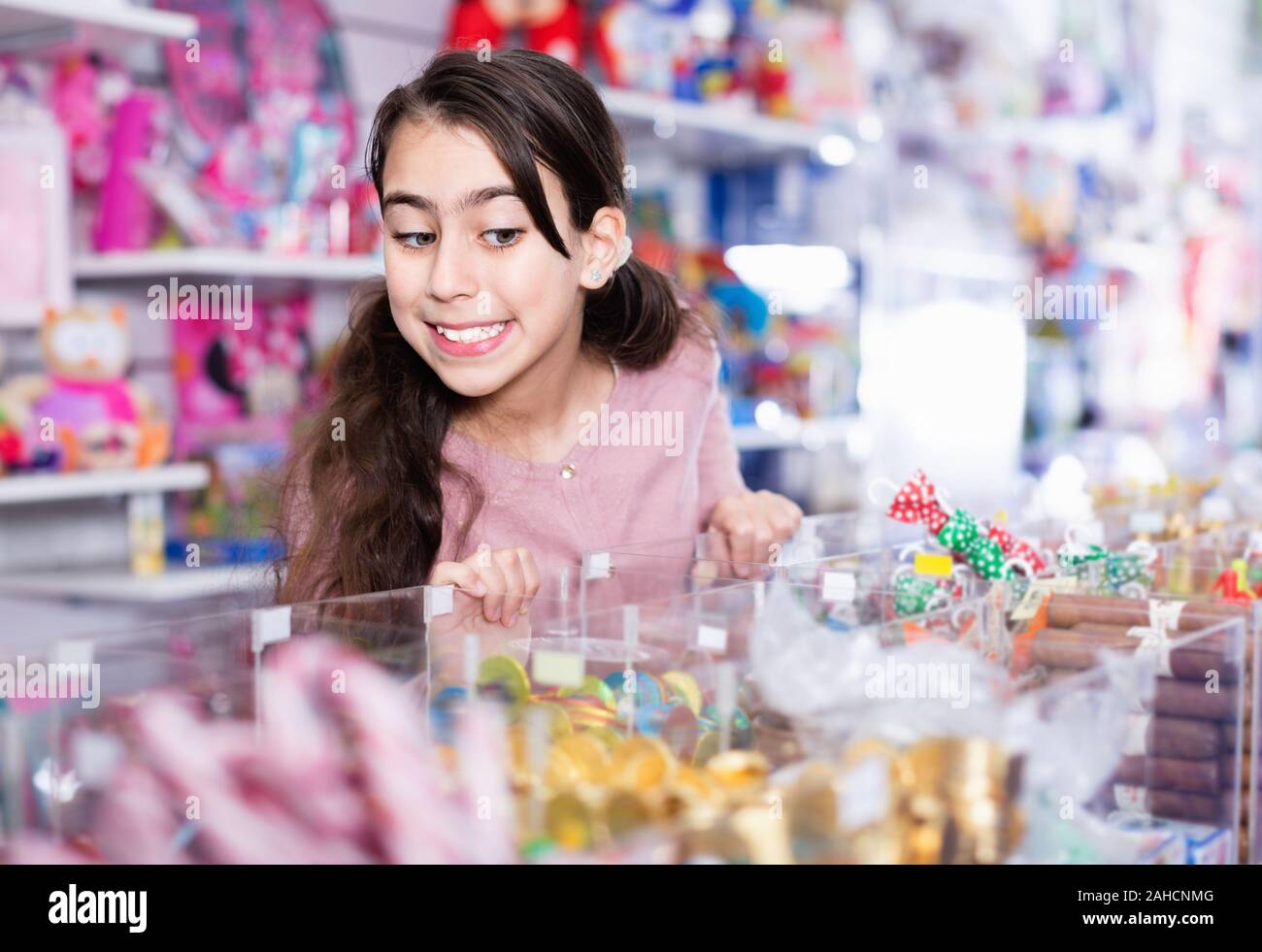 Emotional happy cheerful smiling small girl choosing sweet candies in ...
