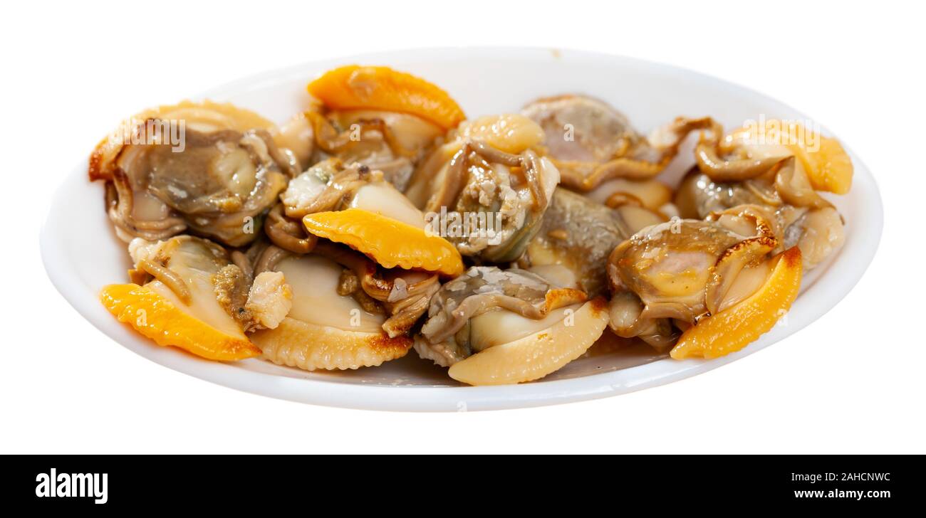 Seafood appetizer. Canned natural shellfish served on white plate ...