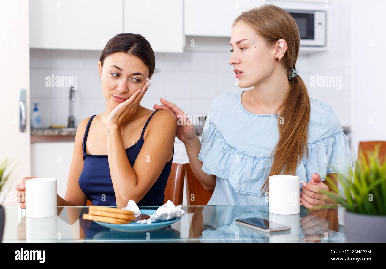 Emotional quarrel between two young women friends in kitchen interior ...