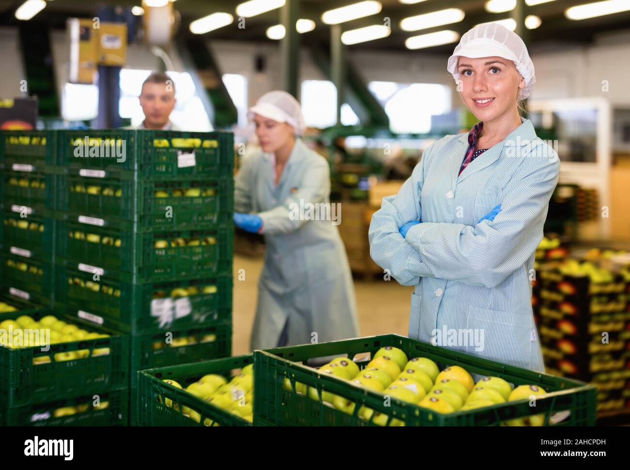 Young glad cheerful positive woman in uniform during sorting at ...