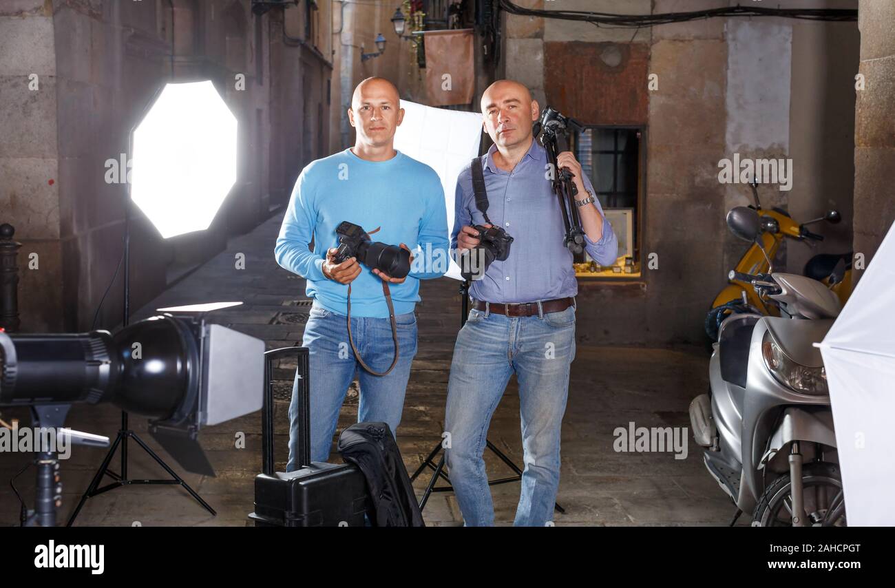 Portrait of two successful photographers with their cameras during ...