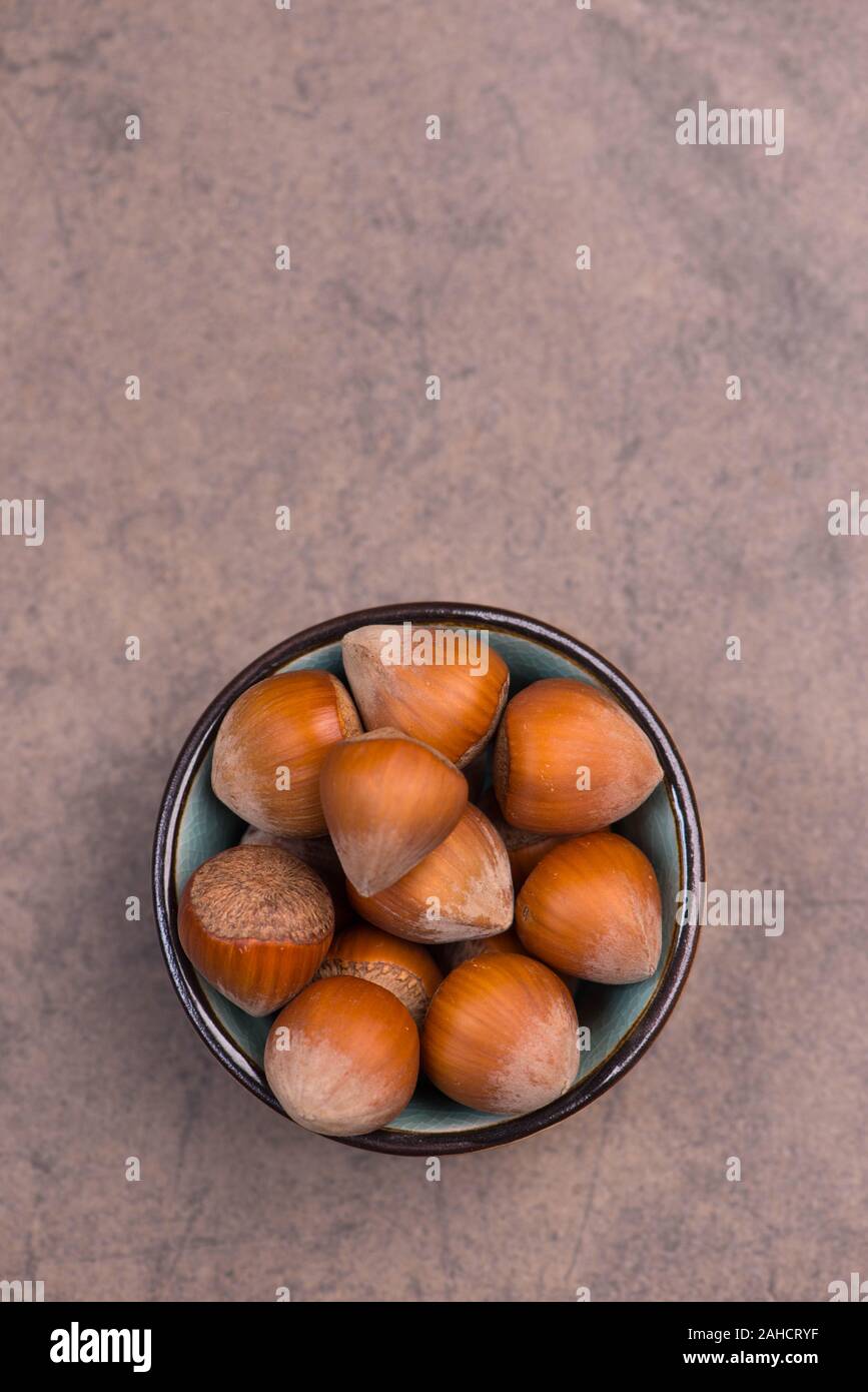 Hazelnuts with the nutshell on a structured background, empty copy ...