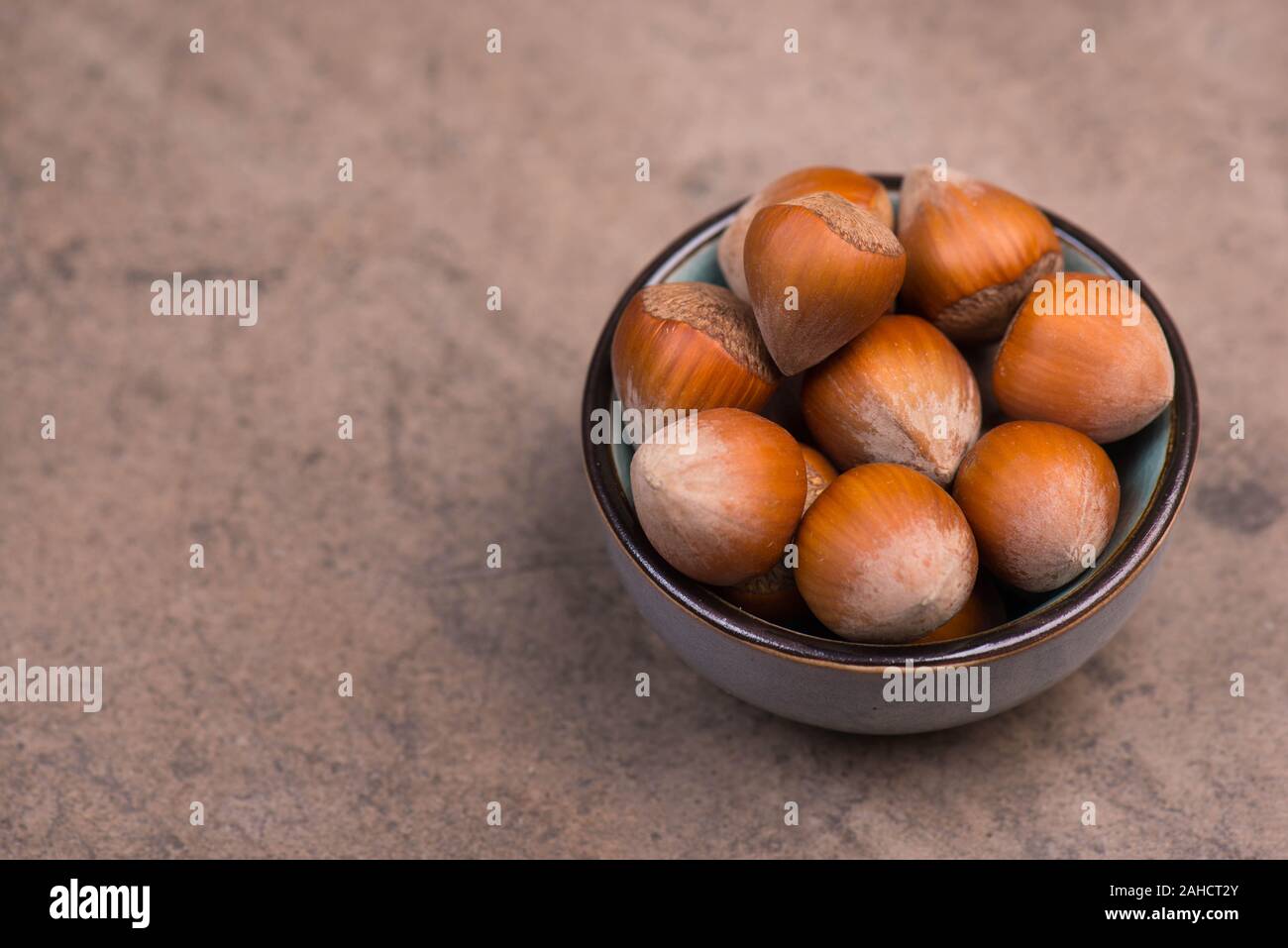 Hazelnuts with the nutshell on a structured background, empty copy ...