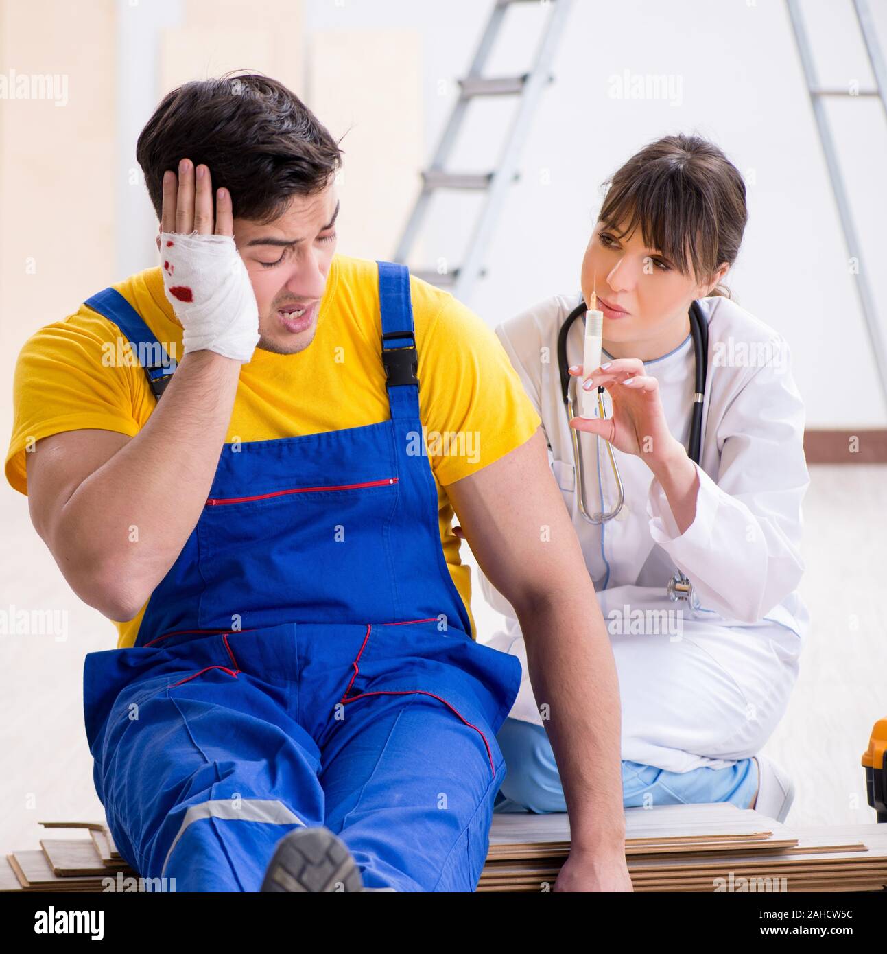 The injured worker being assisted by doctor Stock Photo - Alamy