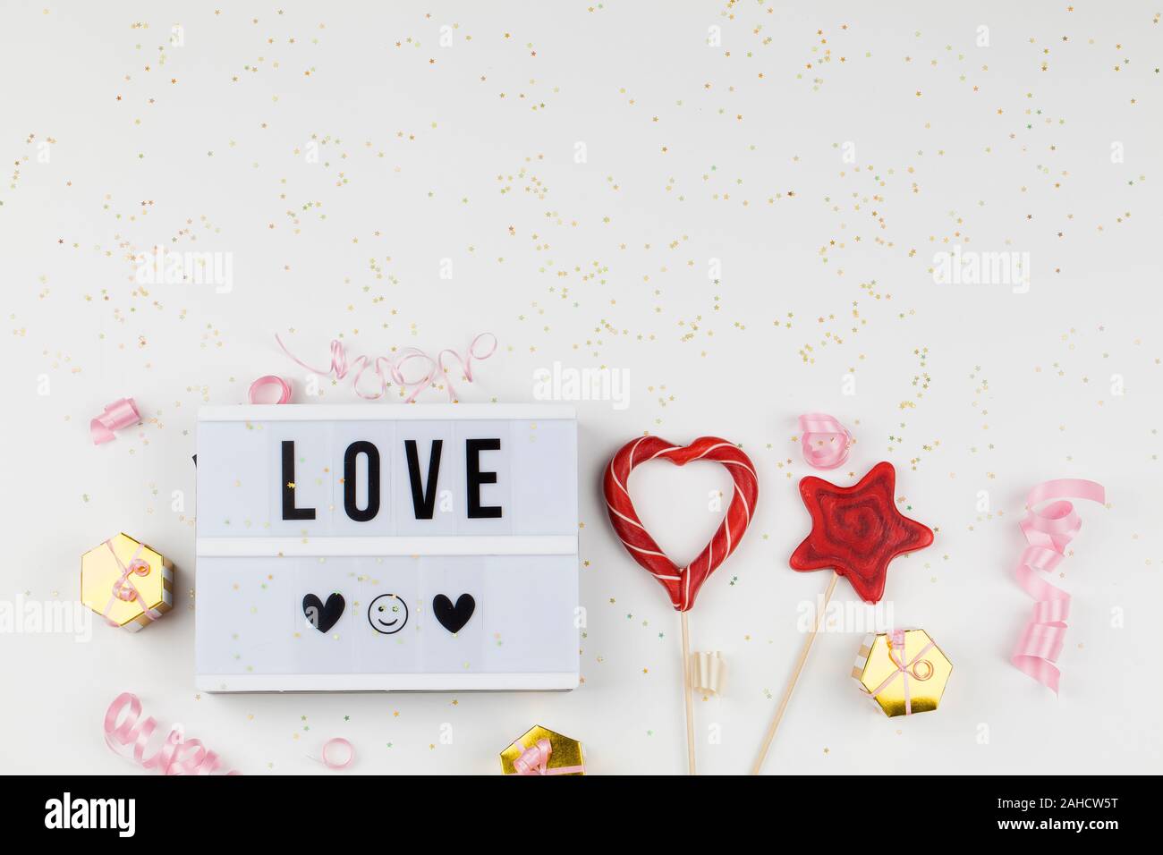 light box with text LOVE, decoration, gifts, red lollipops and ribbon ...