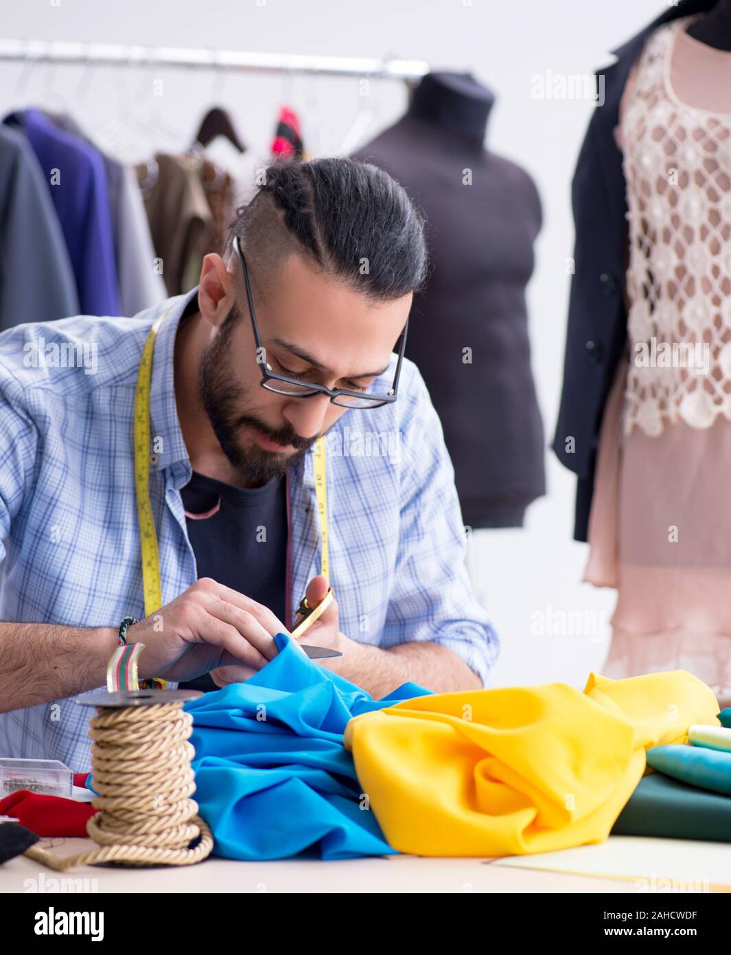 The male tailor working in the workshop on new designs Stock Photo - Alamy