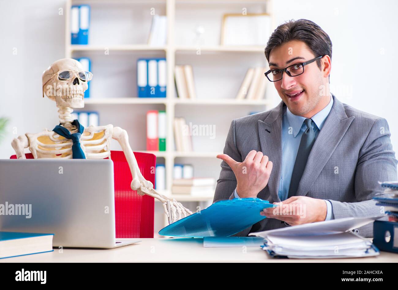 The businessman working with skeleton in office Stock Photo - Alamy