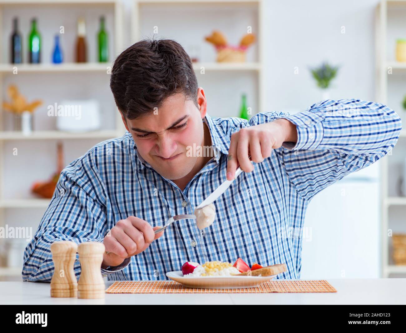The man eating tasteless food at home for lunch Stock Photo - Alamy