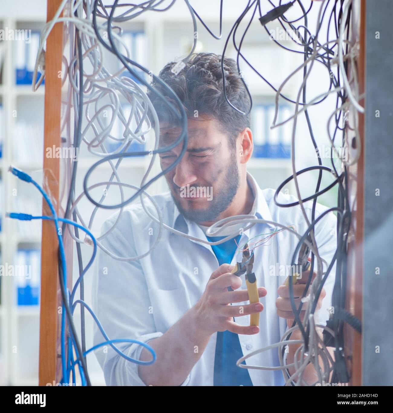 The electrician trying to untangle wires in repair concept Stock Photo ...