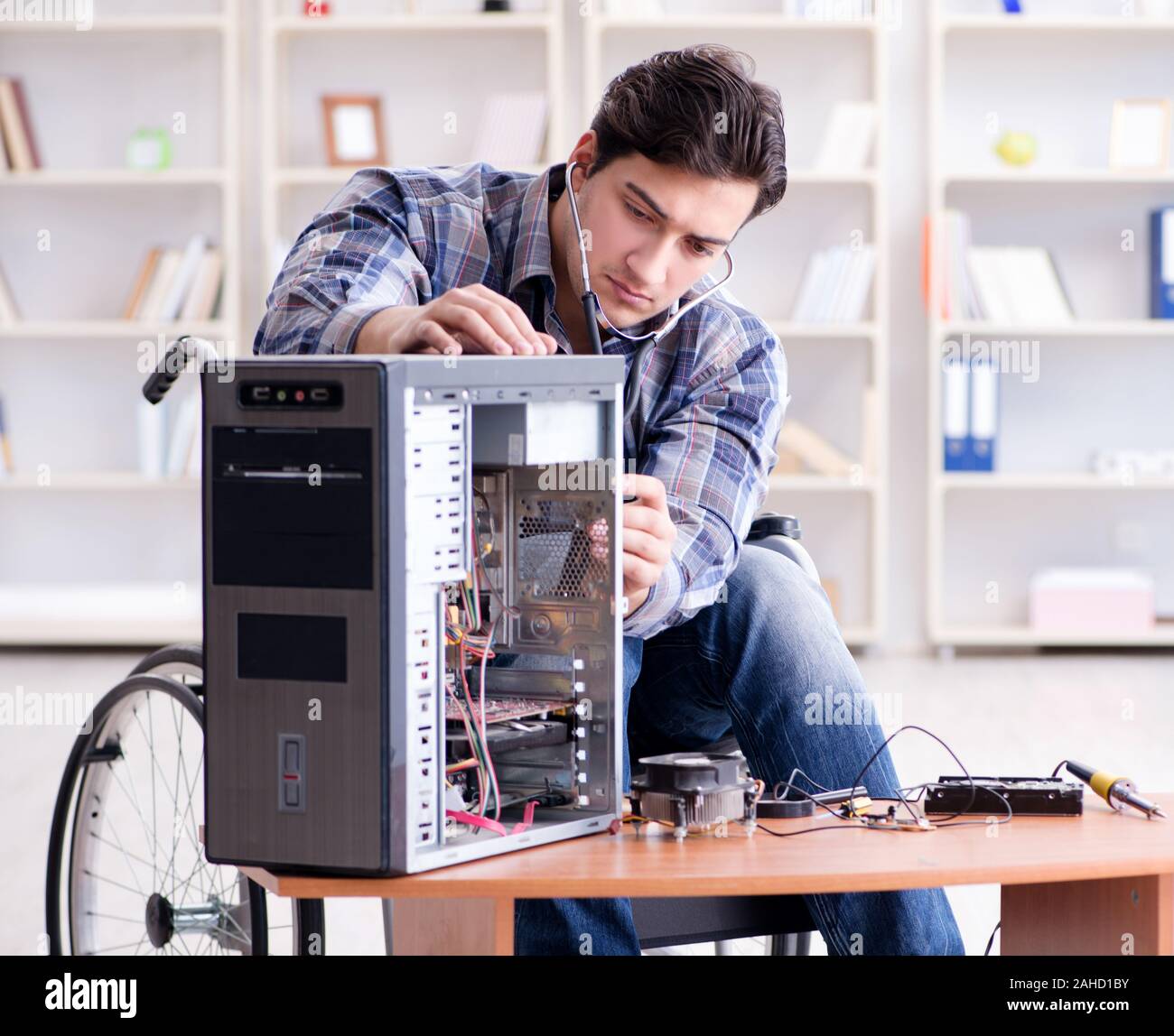 The disabled man on wheelchair repairing computer Stock Photo - Alamy