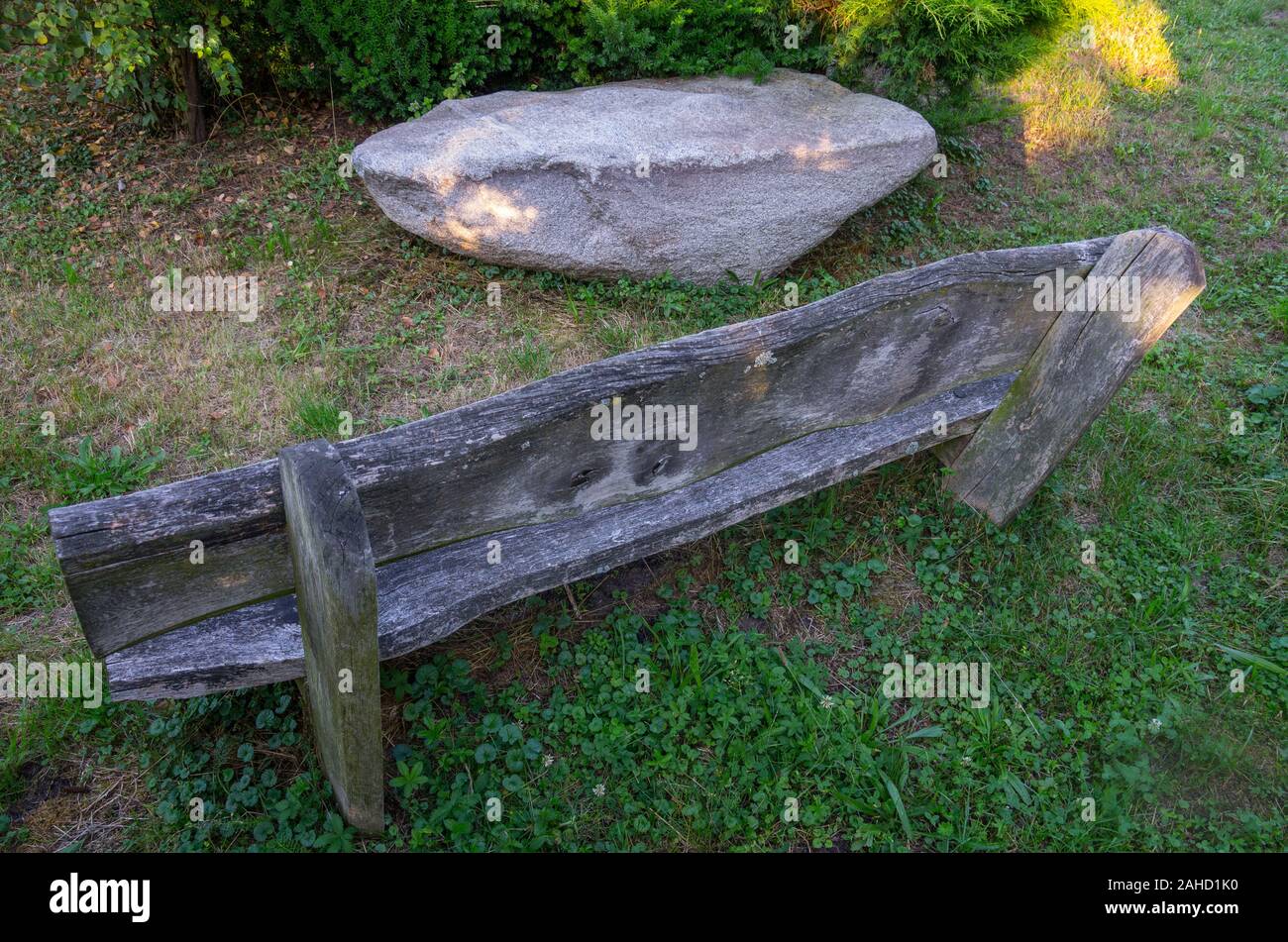 Huge boulder and old bench in the garden Stock Photo - Alamy