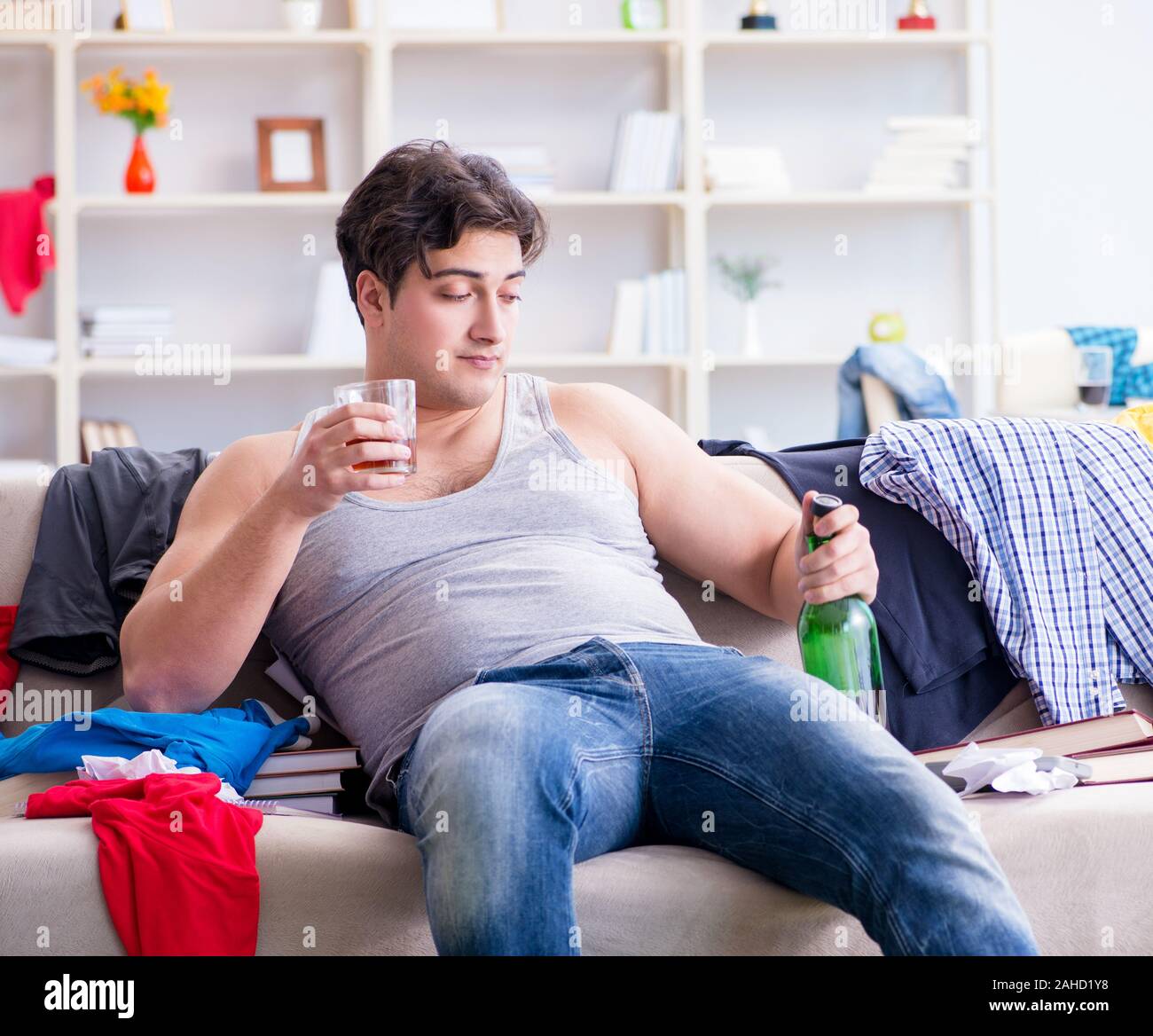 The young man student drunk drinking alcohol in a messy room Stock ...