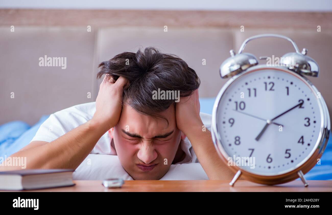 Man in bed frustrated suffering from insomnia with an alarm clock Stock ...