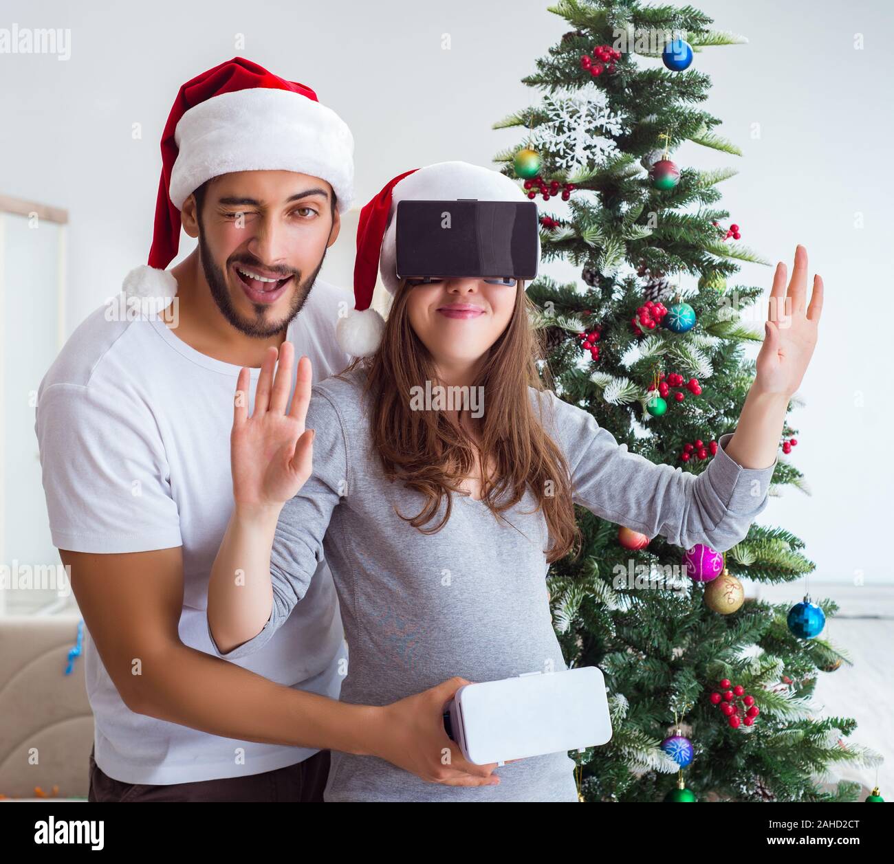 Young family expecting child baby wearing virtual reality VR glasses ...