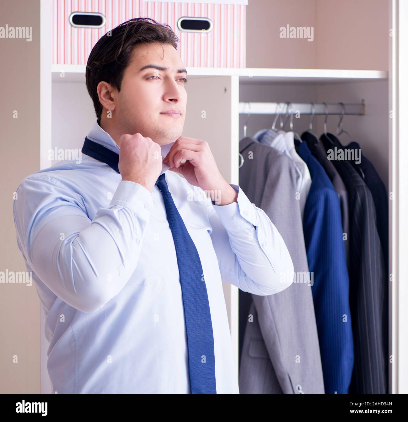 The young man businessman getting dressed for work Stock Photo - Alamy