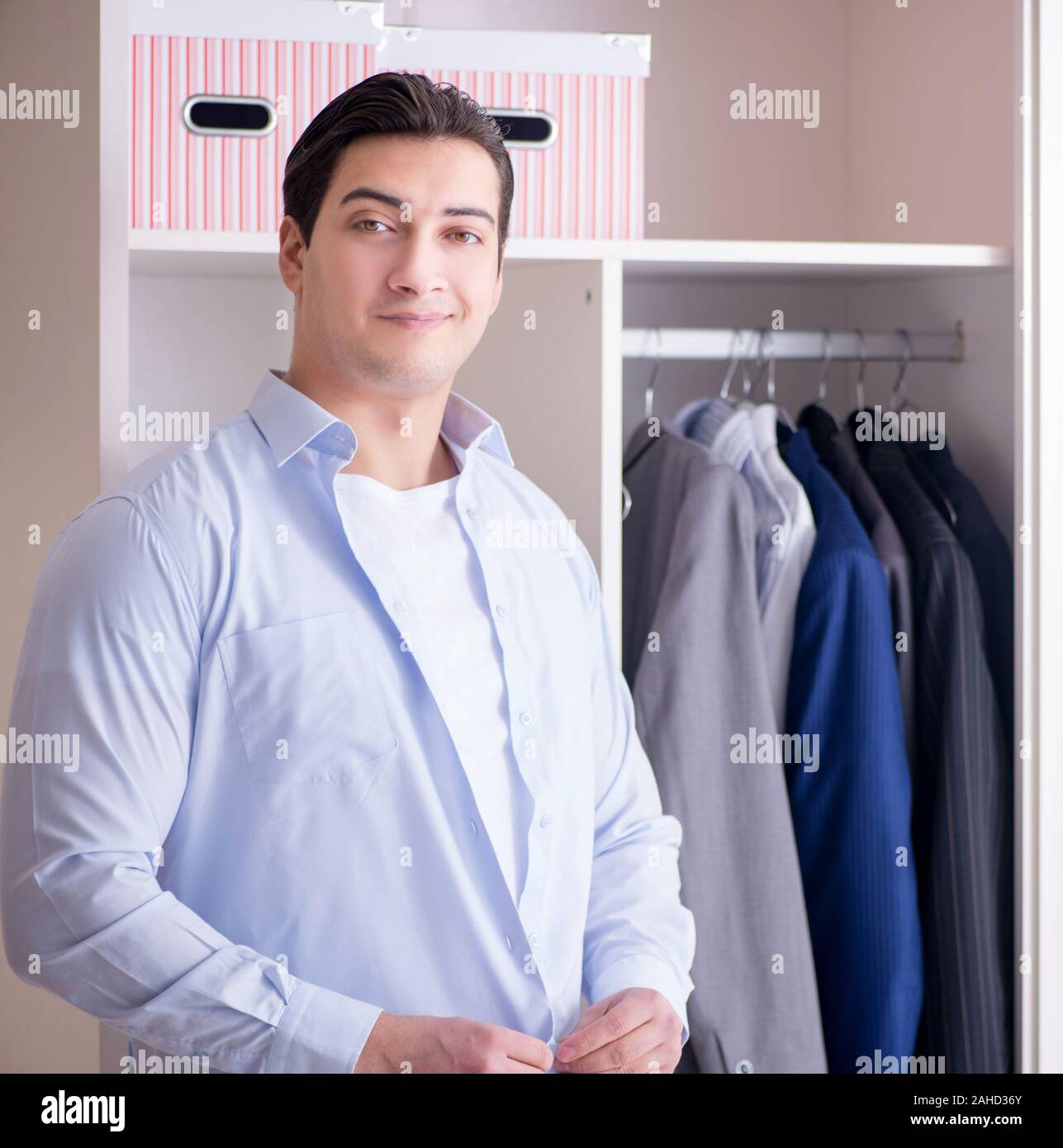The young man businessman getting dressed for work Stock Photo - Alamy
