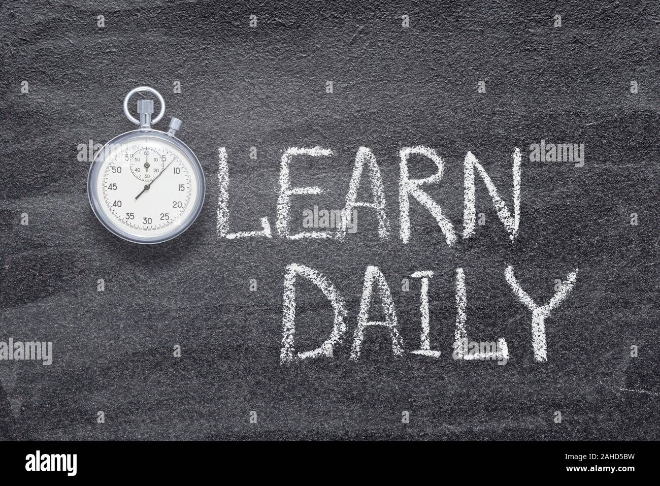 learn daily phrase written on chalkboard with vintage precise stopwatch ...