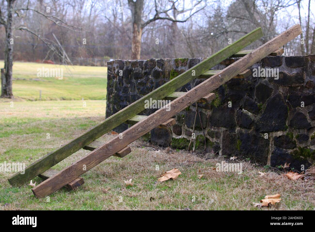 The ladder is leaning against the stone wall Stock Photo - Alamy