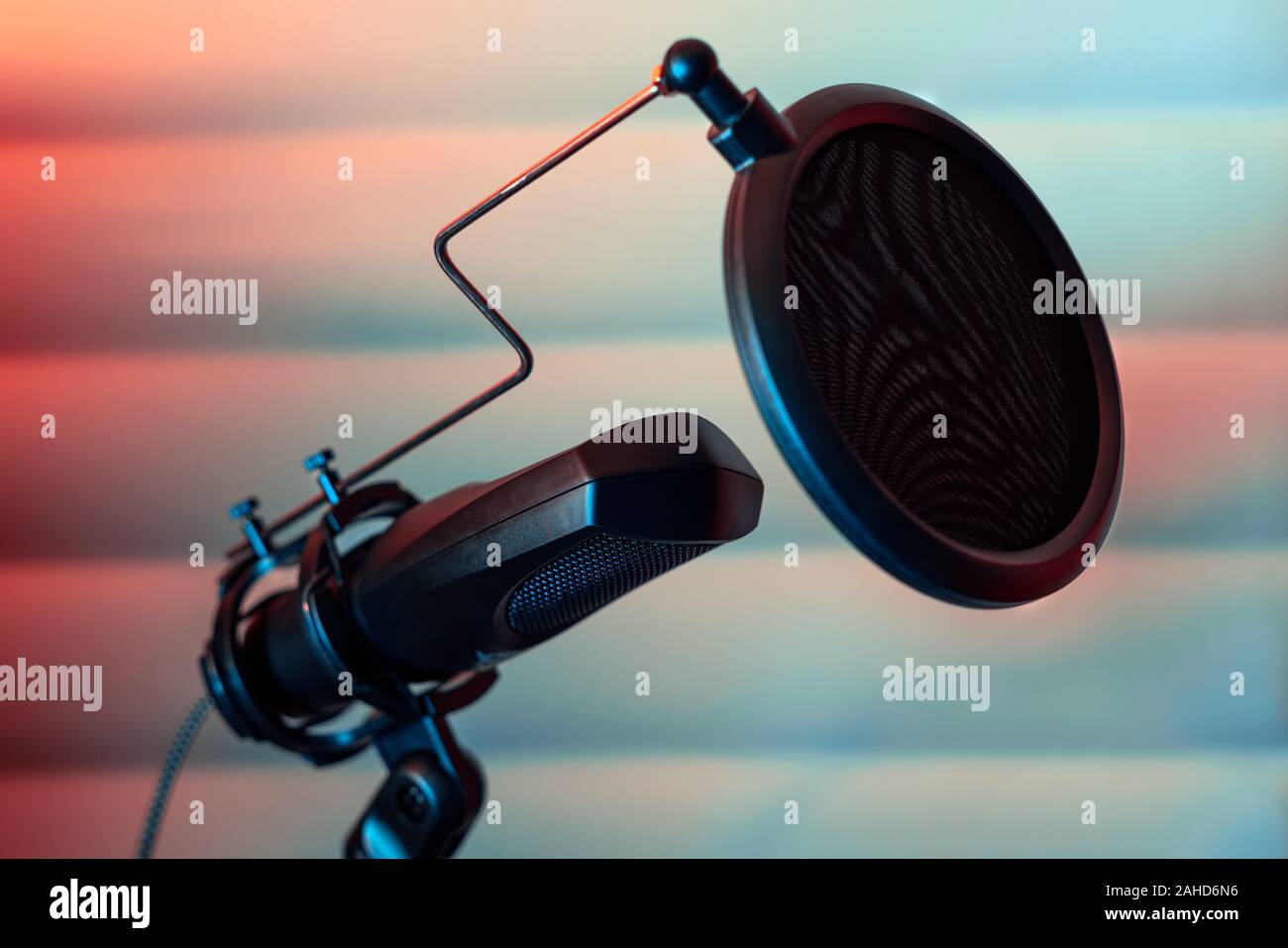 Condenser microphone placed on a tripod with acustic panels in the ...