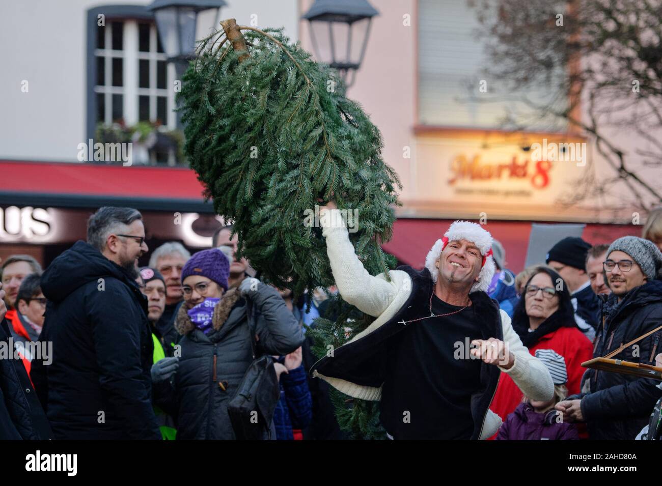 Hilden, Germany. 28th Dec, 2019. A participant throws a Christmas tree ...