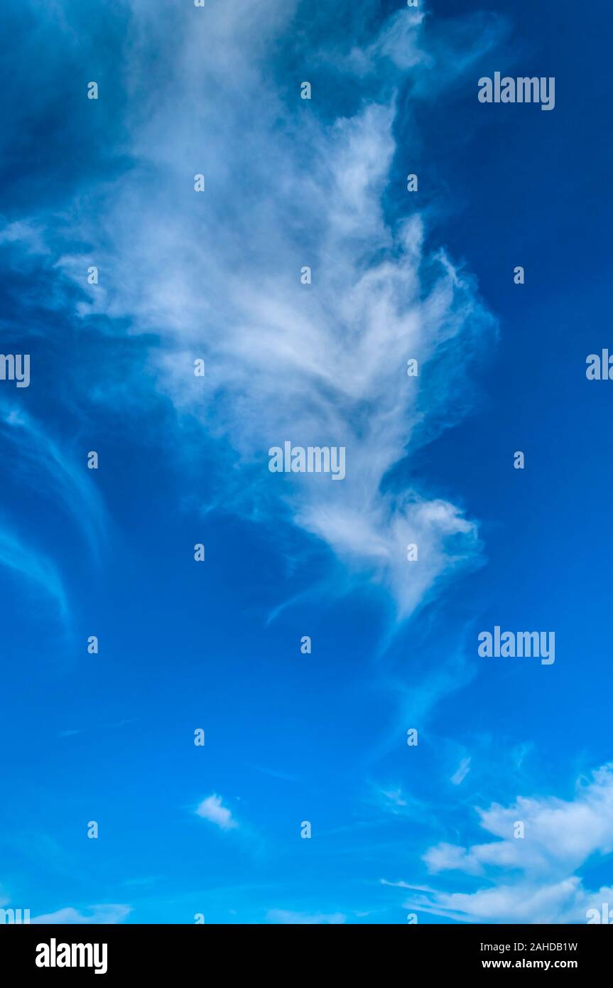 Swirling high cirrus clouds on a brilliant blue sky in summer Stock ...