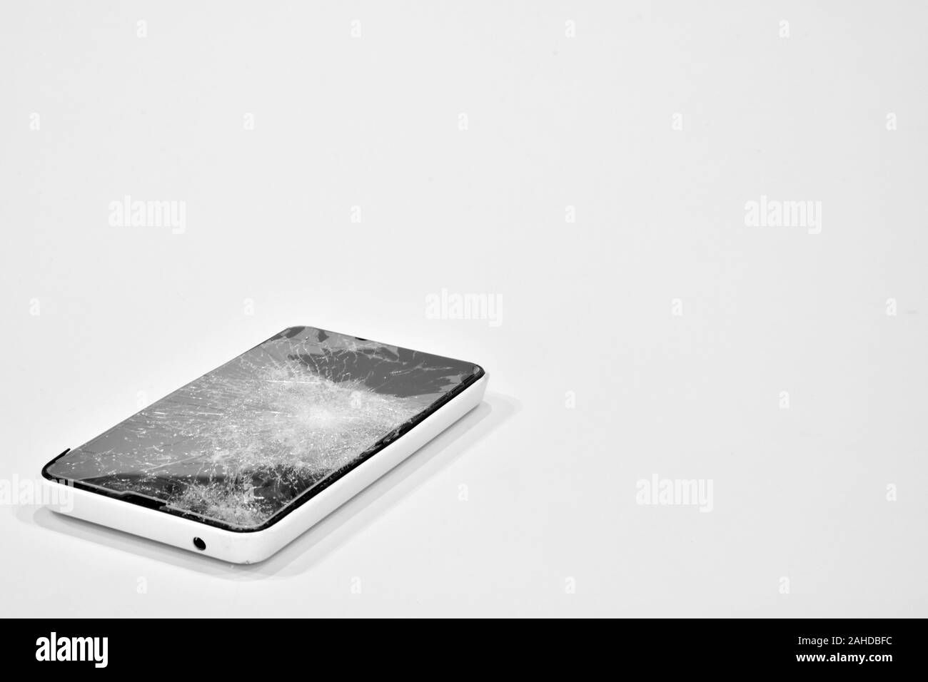 Cell phone with the screen broken by a hammer. Smart phone with the ...