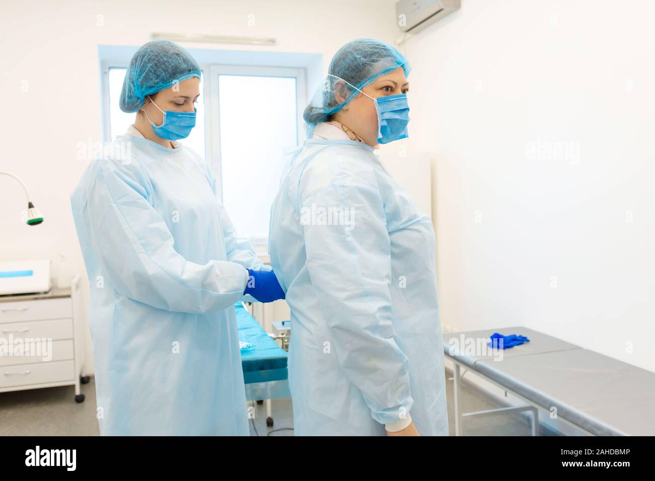 A nurse dresses a surgeon in a sterile suit before surgery Stock Photo ...
