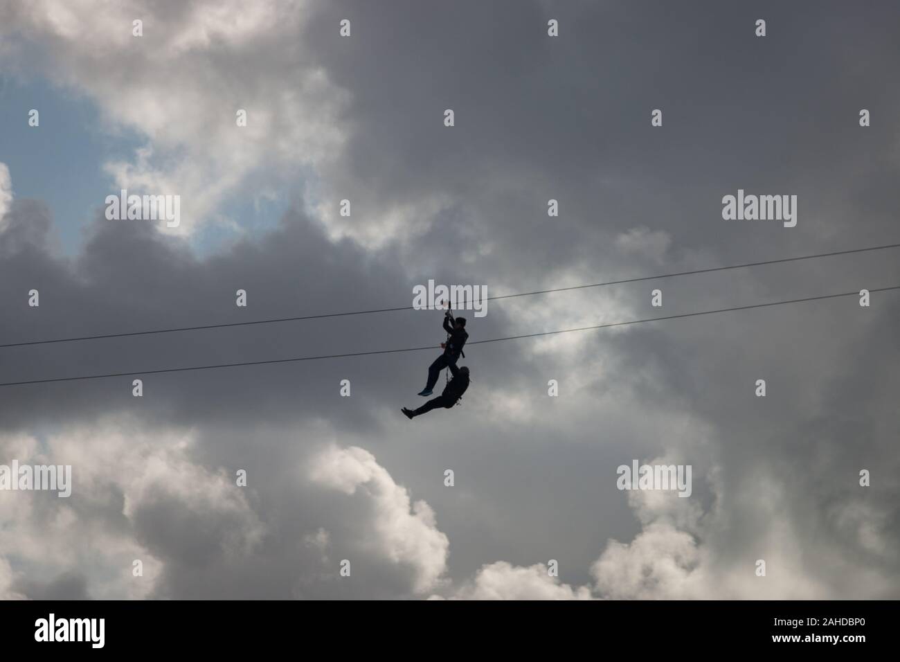 Two people having fun using a zip line at Scheveningen beach, the ...