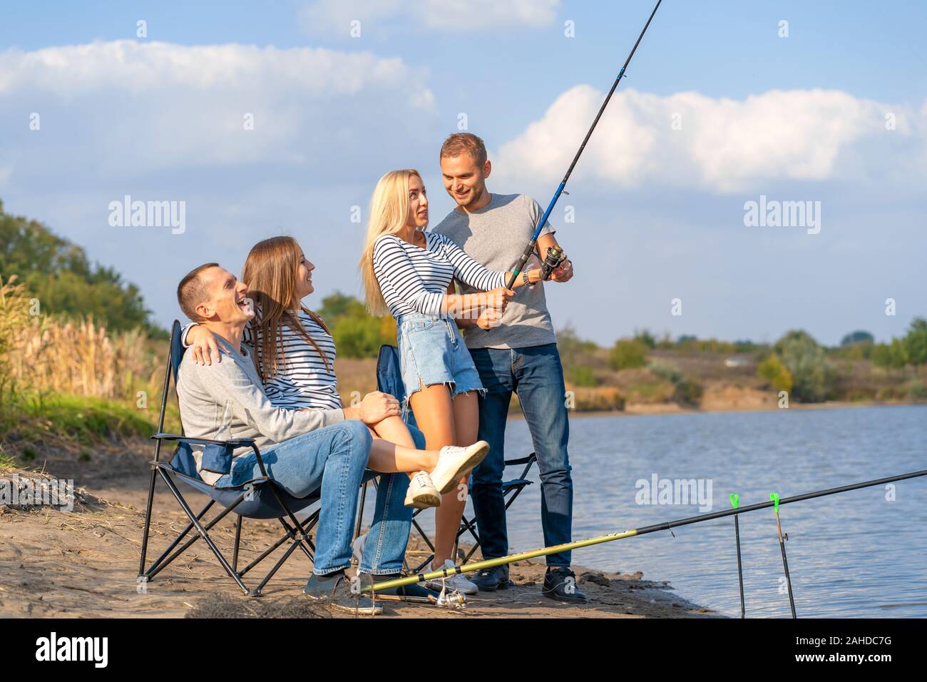Group of young friends fishing on the pier by lakeside Stock Photo - Alamy