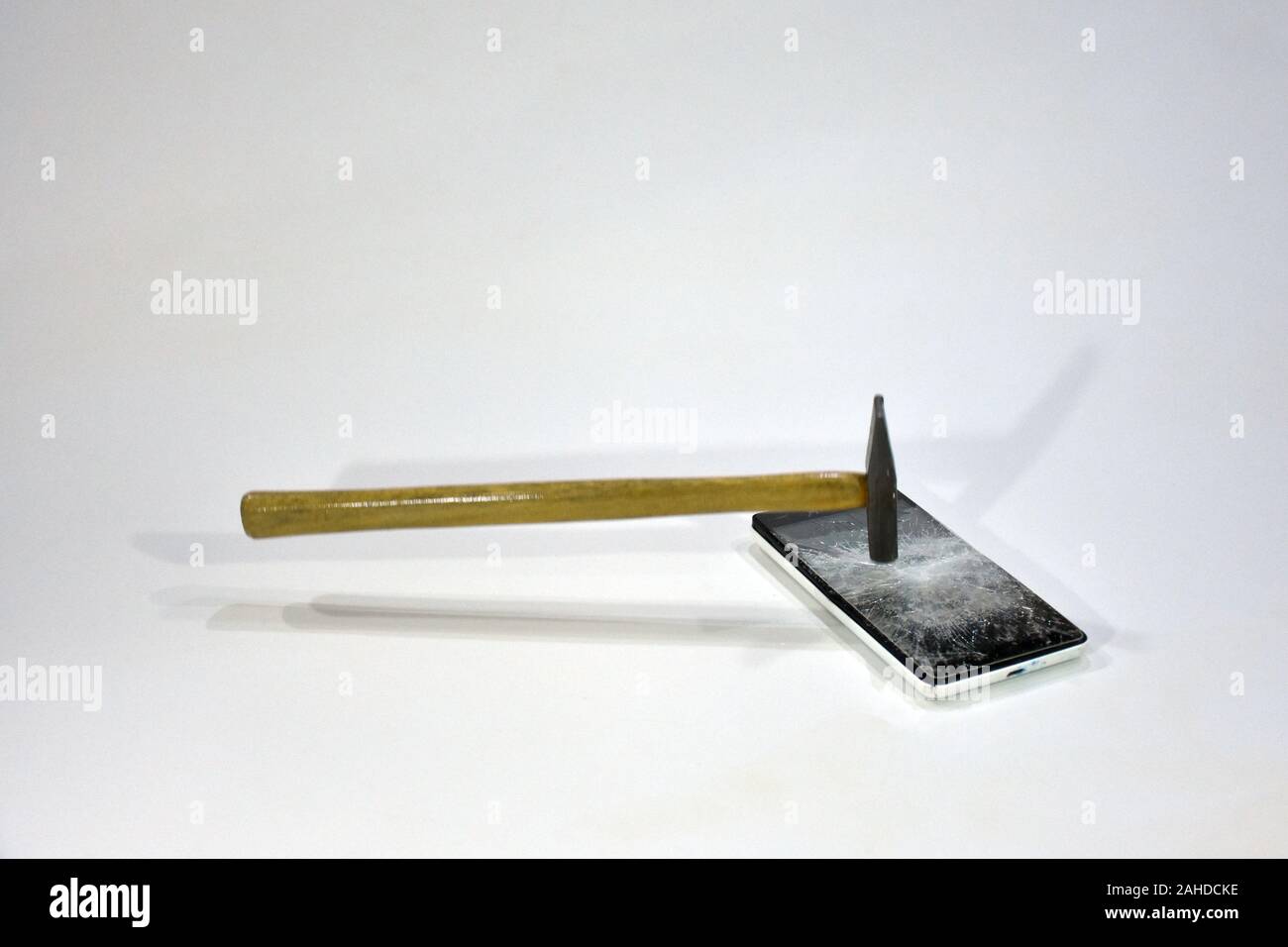 Cell phone with the screen broken by a hammer. Smart phone with the ...