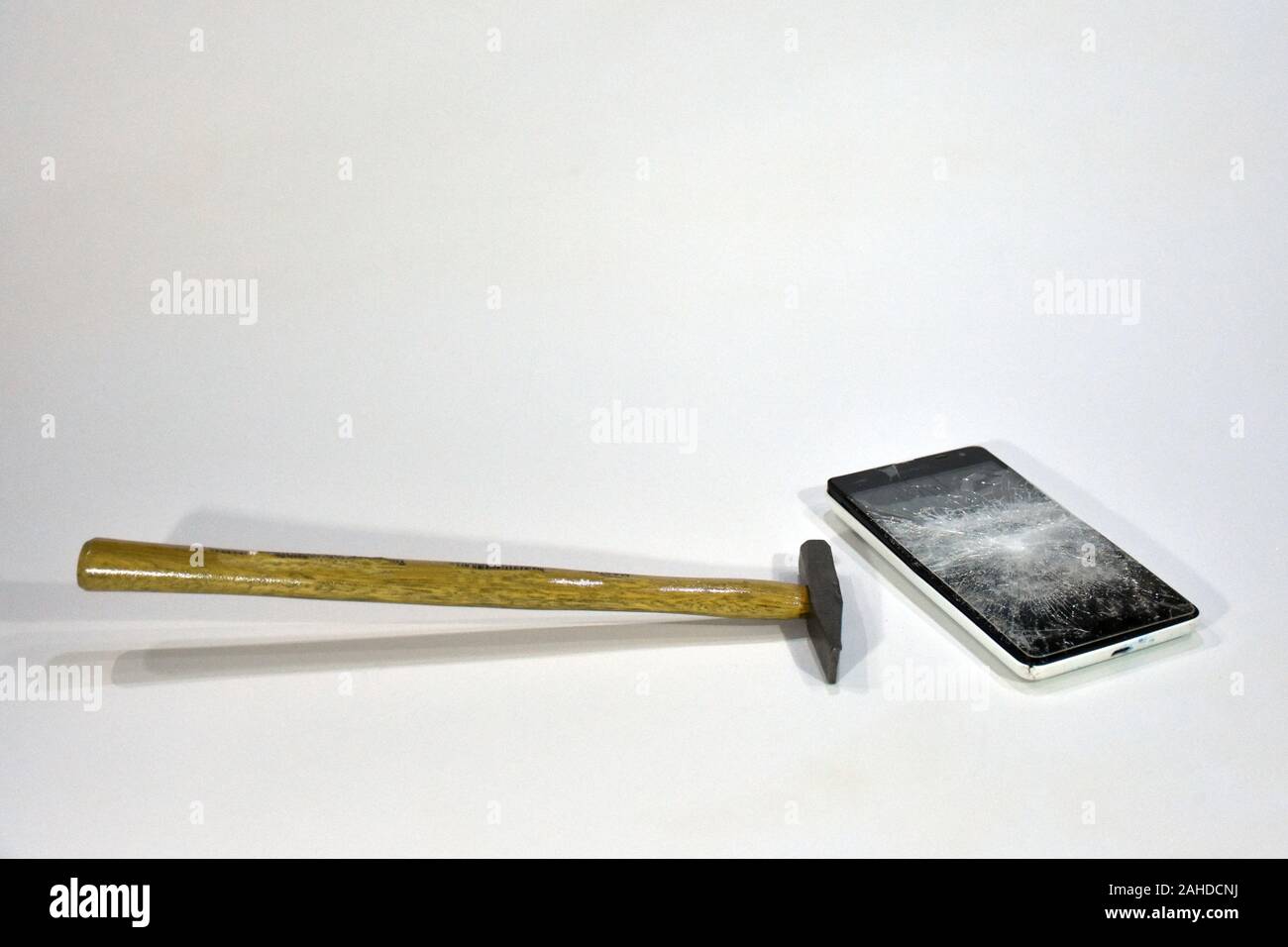 Cell phone with the screen broken by a hammer. Smart phone with the ...