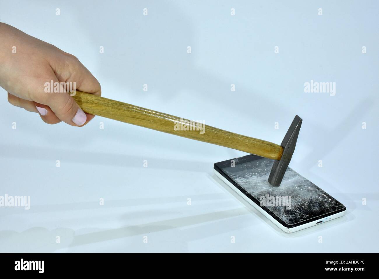 Cell phone with the screen broken by a hammer. Smart phone with the ...