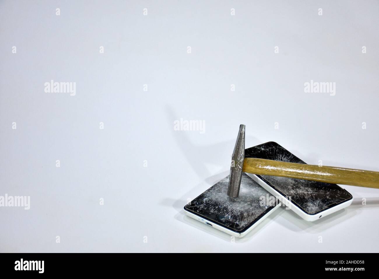 Cell phone with the screen broken by a hammer. Smart phone with the ...