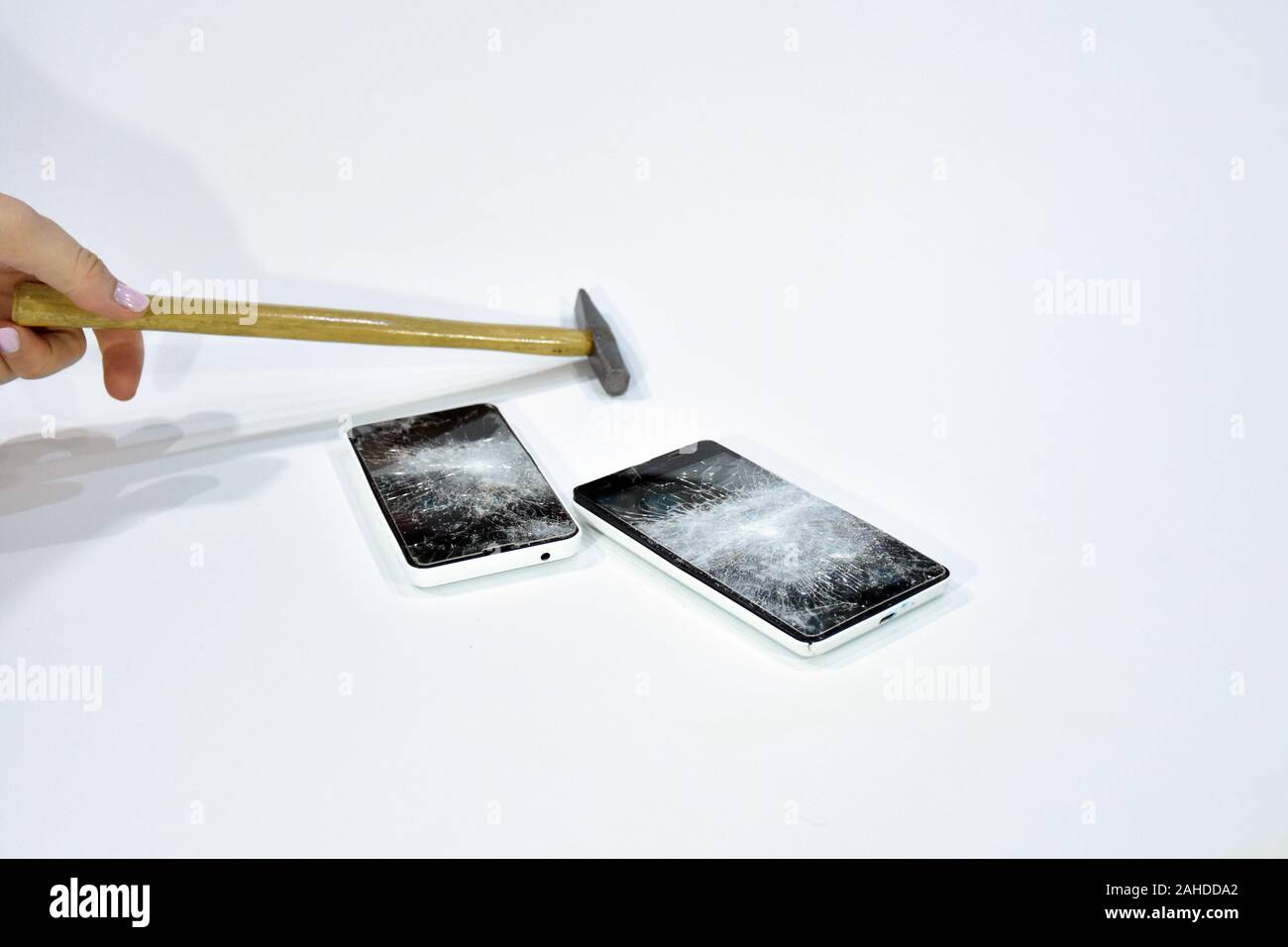 Cell phone with the screen broken by a hammer. Smart phone with the ...