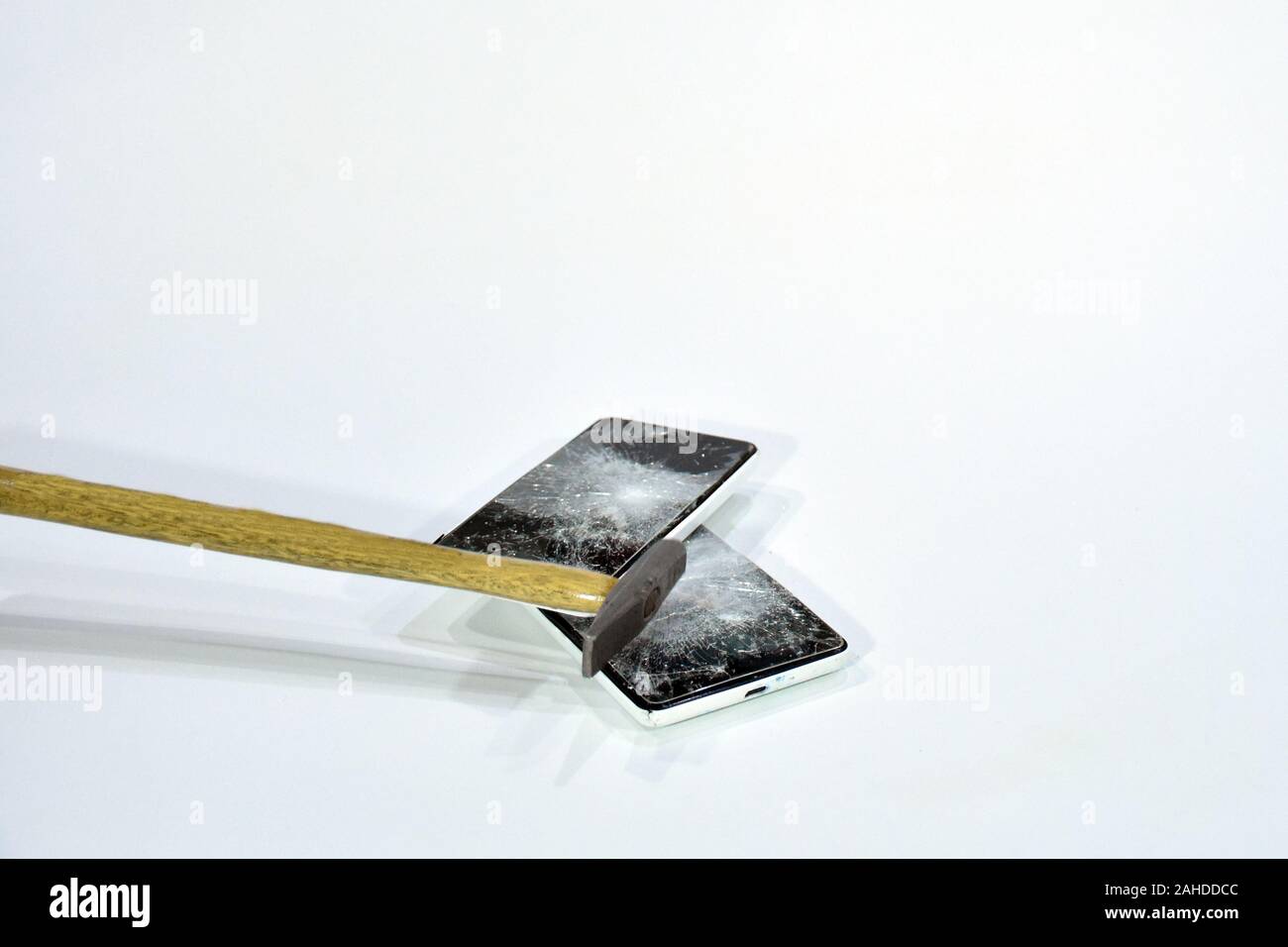 Cell phone with the screen broken by a hammer. Smart phone with the ...
