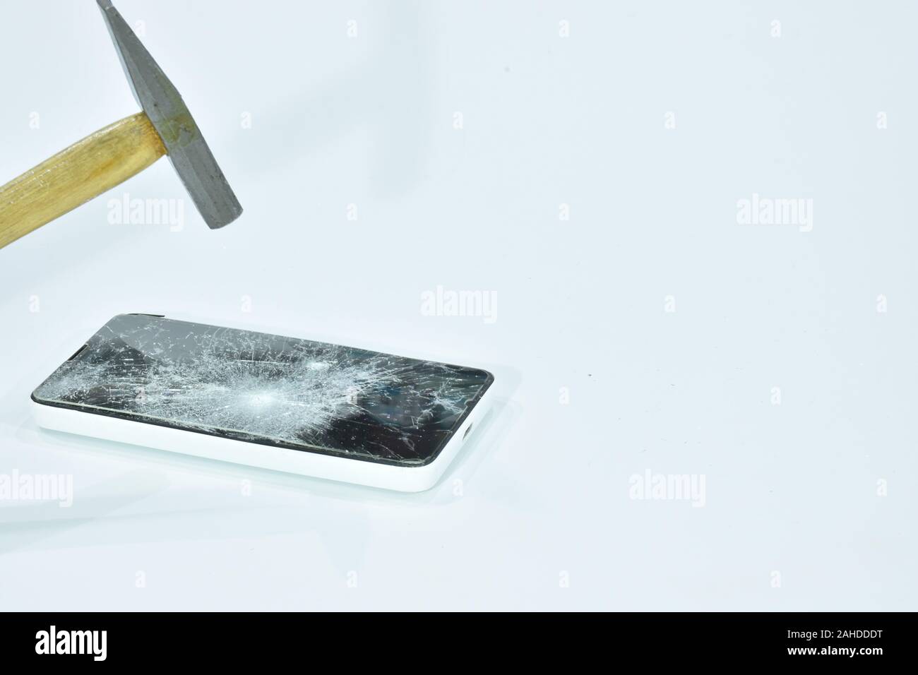 Cell phone with the screen broken by a hammer. Smart phone with the ...