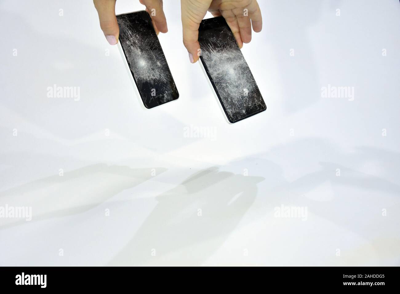 Cell phone with the screen broken by a hammer. Smart phone with the ...