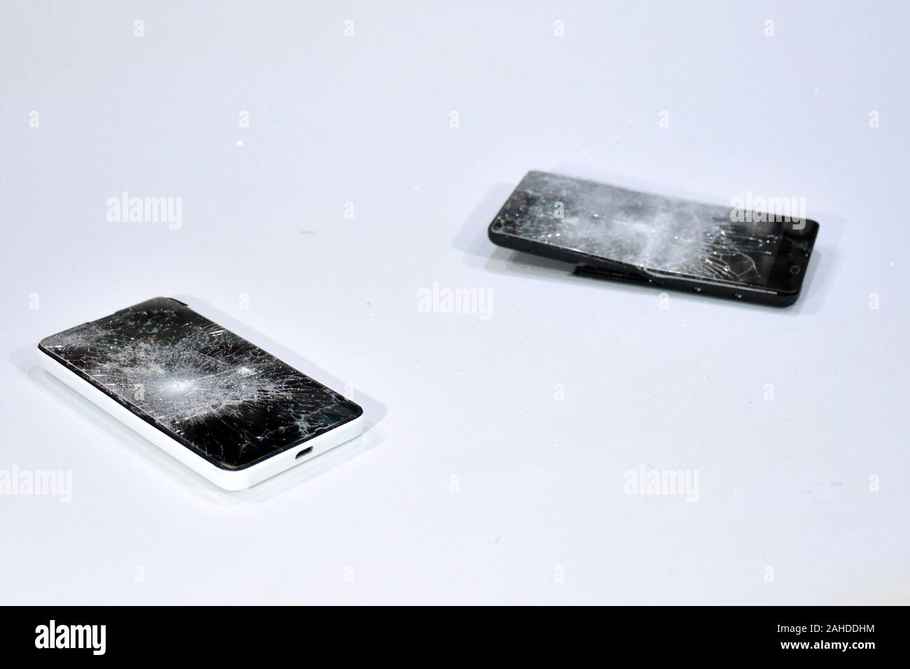 Cell phone with the screen broken by a hammer. Smart phone with the ...