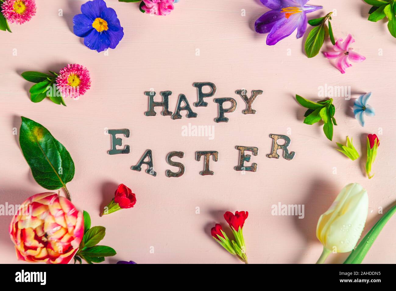 Happy Easter letters with different spring flowers around them, flat ...