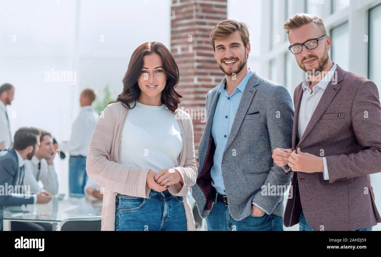 three young employees standing in a modern office Stock Photo - Alamy