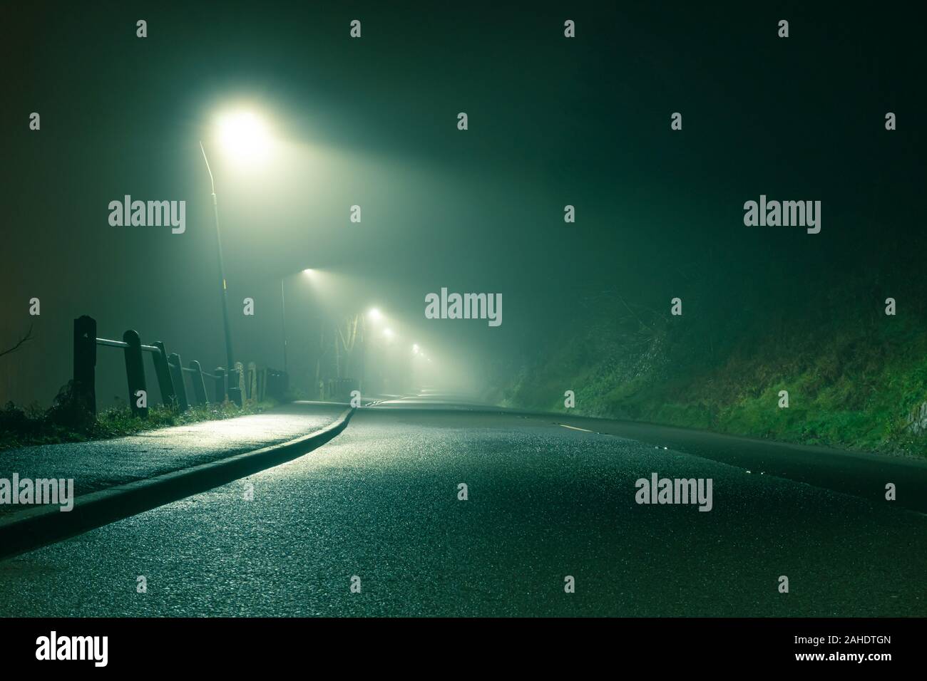 Low angle of a spooky country road, going into the distance with street ...