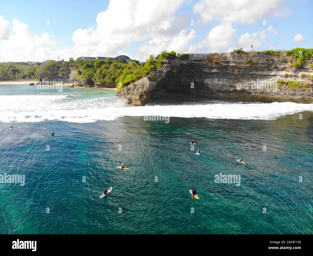 Aerial view of surfer on their board waiting the waves next the cliff ...