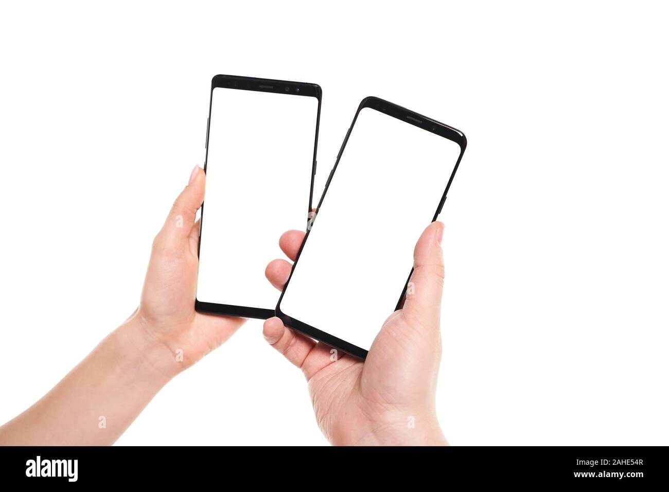 Two hands holding smartphones blank screen with modern frameless design ...
