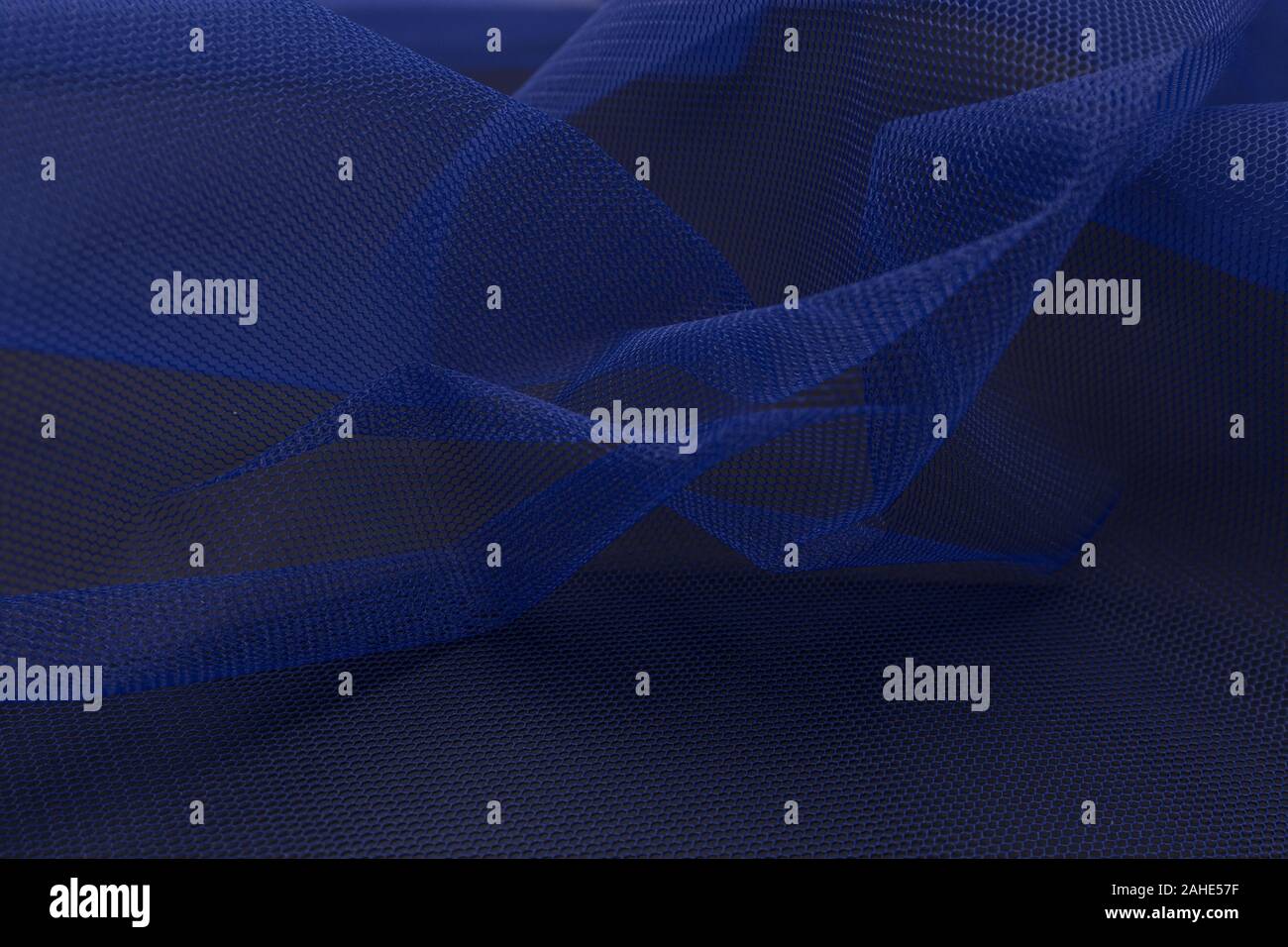 Beautiful close up of blue tulle fabric with textile texture background ...