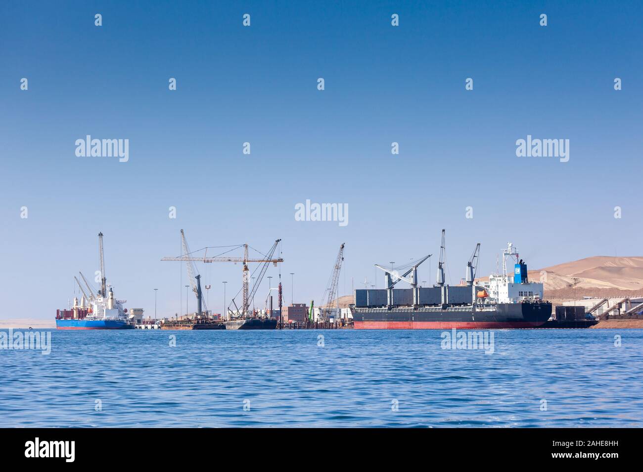 Paracas, Peru - 2019-12-05. Cargo ships, cargo cranes are in port for ...
