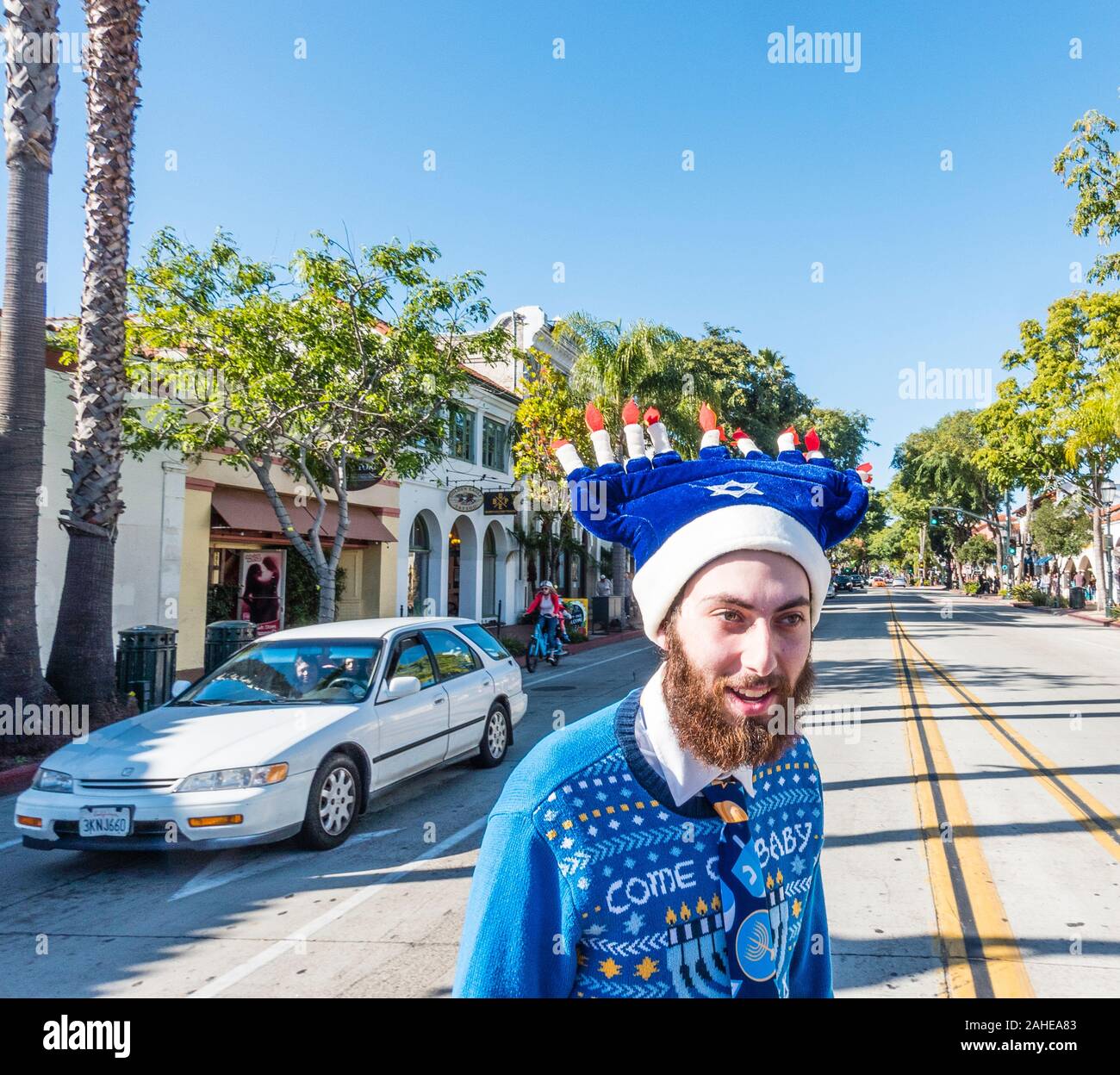 A Jewish male wearing a menorah on his hat, tie and sweater, and tie ...