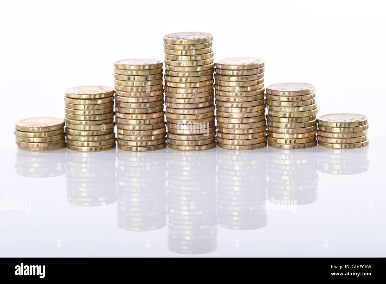 A stack of Australian one dollar gold coins set against a white ...