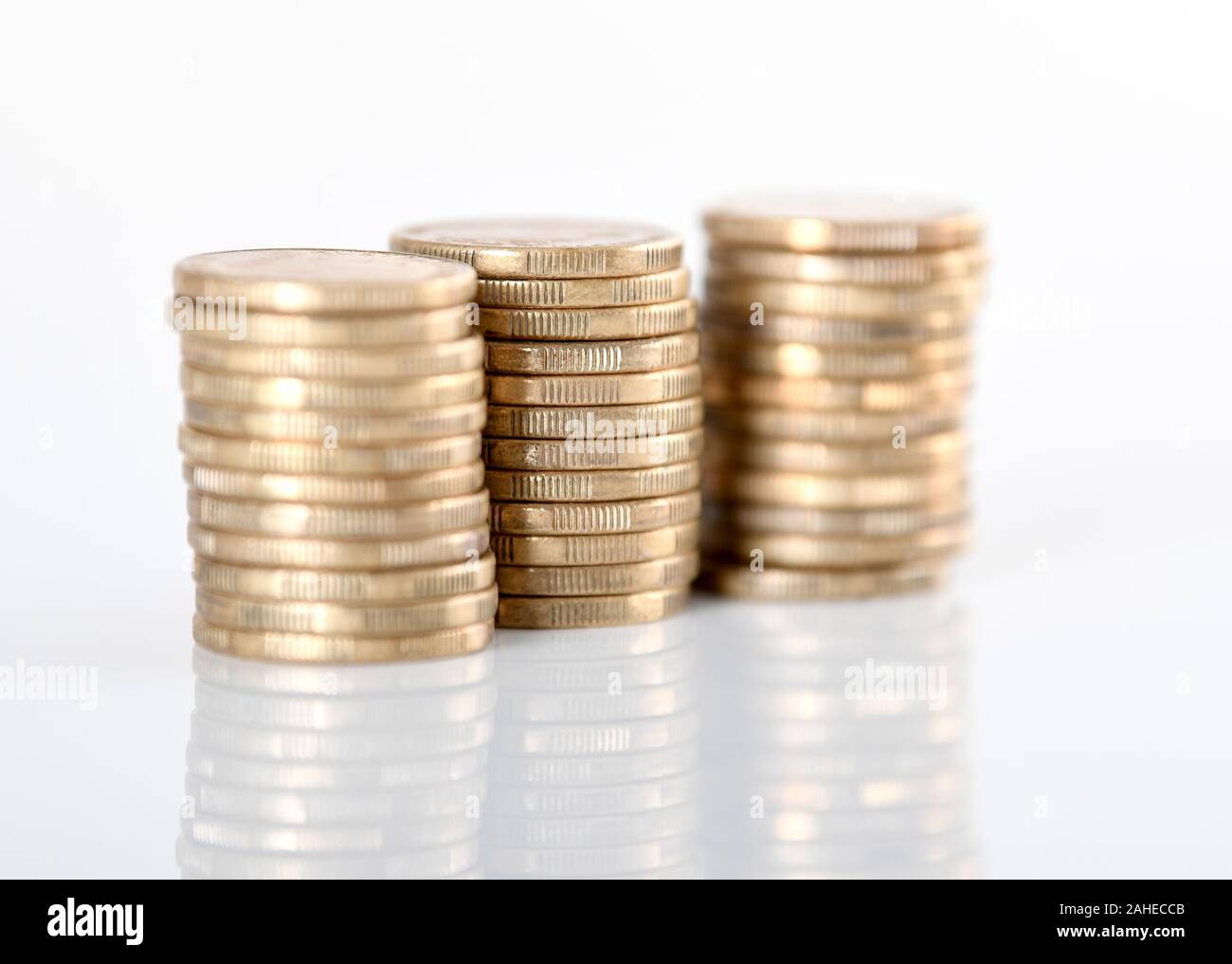 A stack of Australian one dollar gold coins set against a white ...