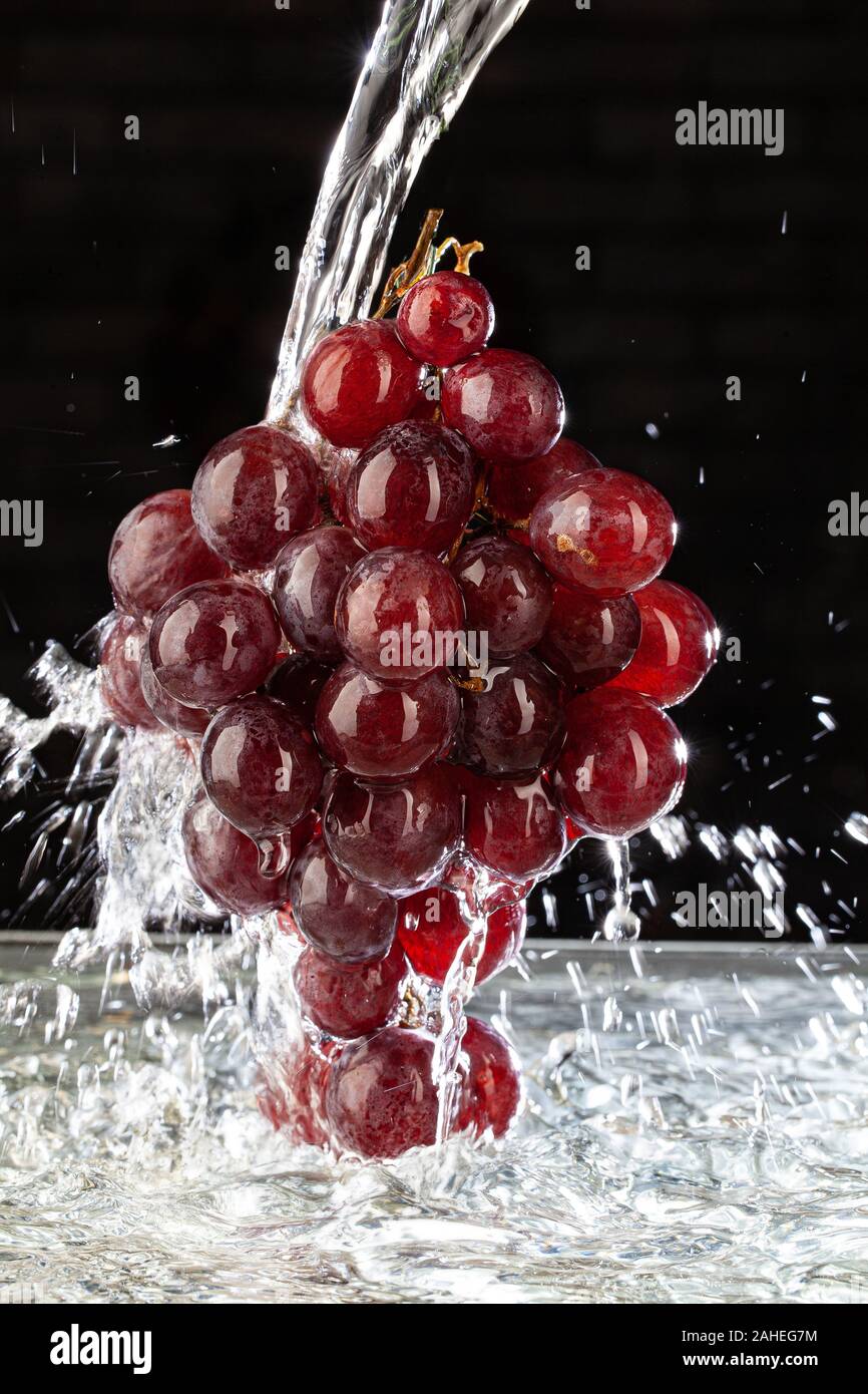 Bunch of grapes and stream of water on a studio background Stock Photo ...