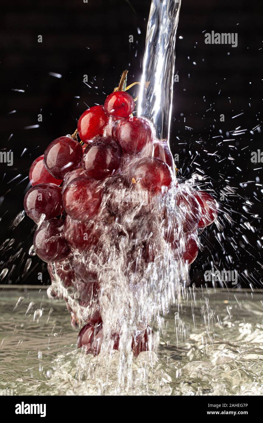 Bunch of grapes and stream of water on a studio background Stock Photo ...